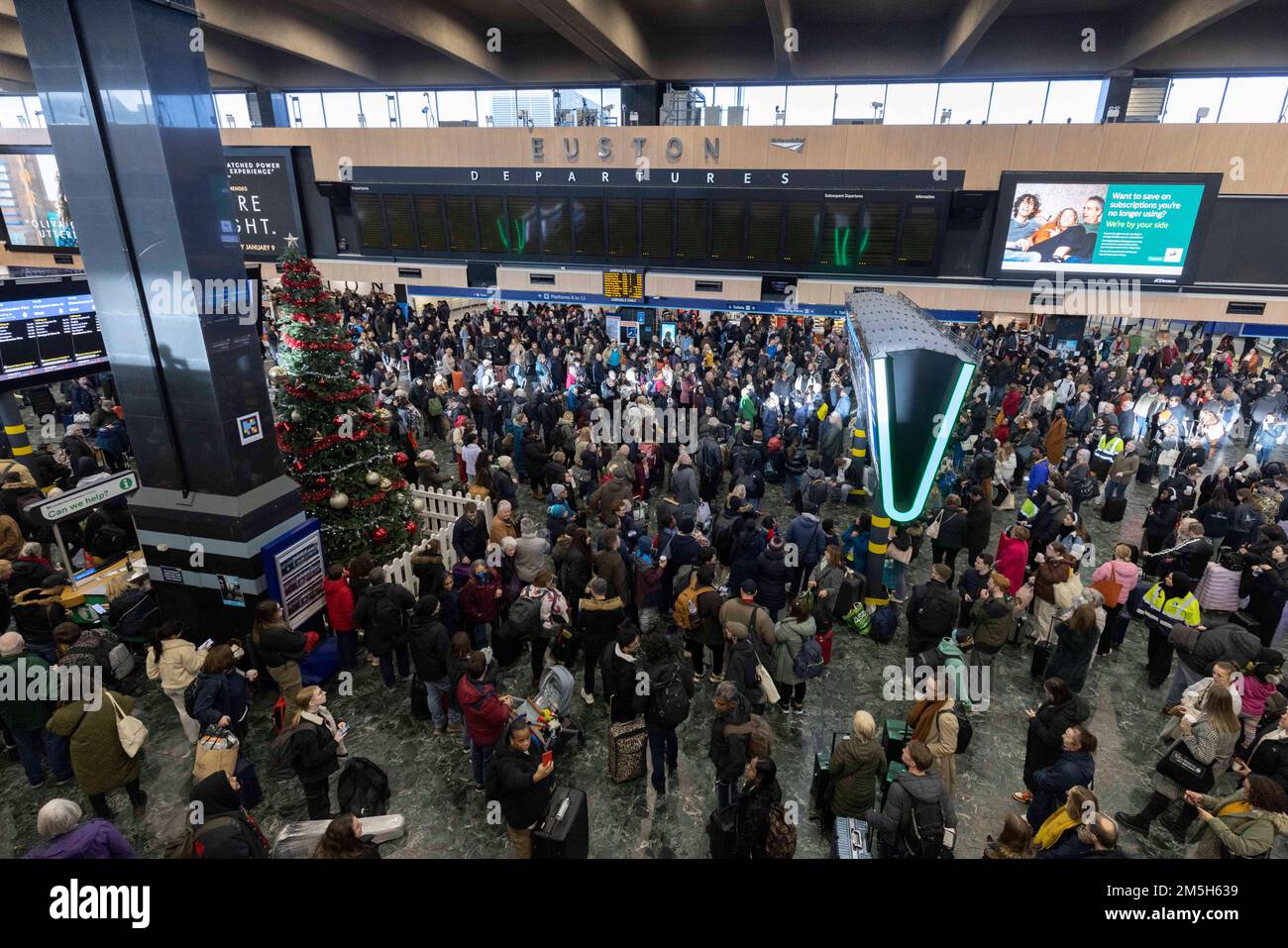 Passengers look at notice boards at Euston train station in London ...