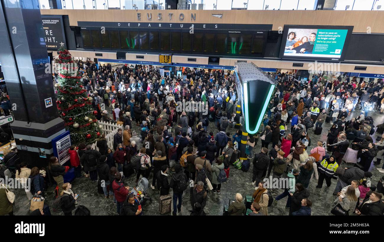 Passengers look at notice boards at Euston train station in London ...