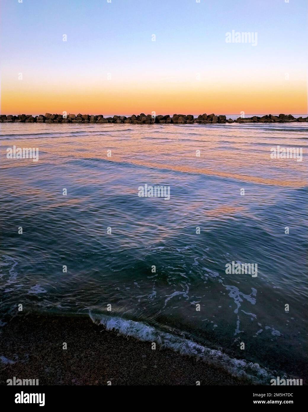 early morning sea, ocean during sunrise with red tons on the clouds ...