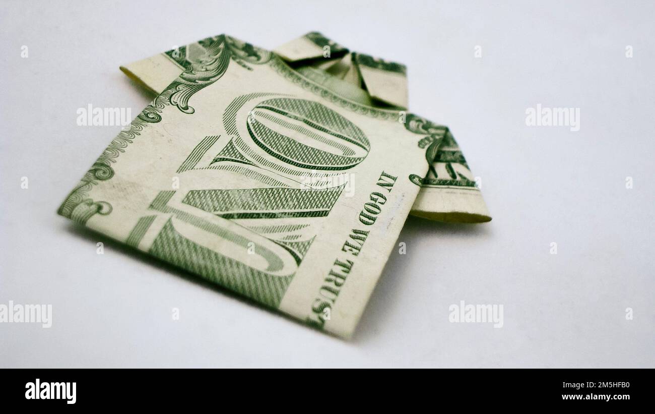 An American dollar bill folded as a shirt origami on the empty white ...