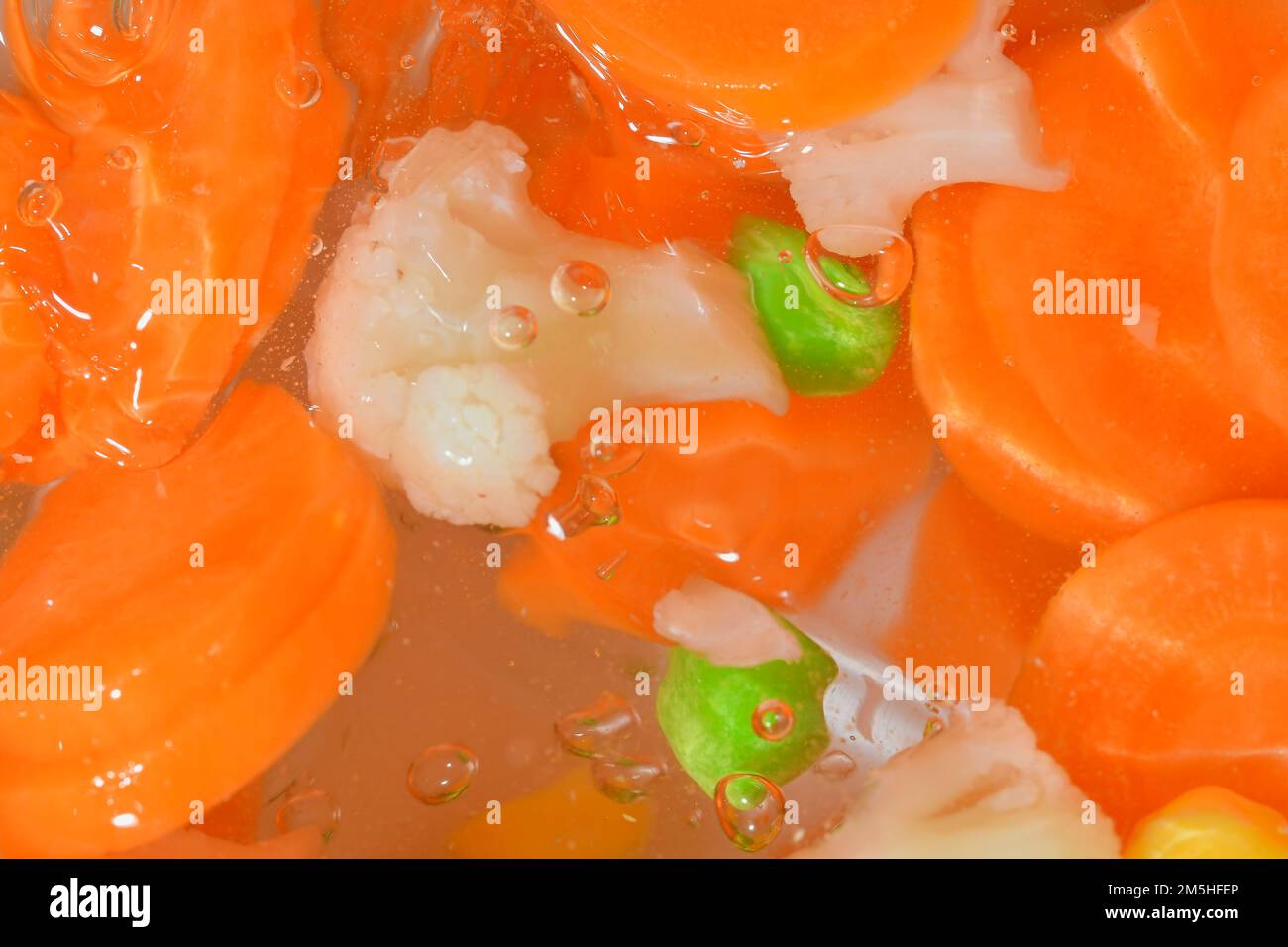 Close-up fresh soup vegetables with carrots, peas, cauliflower and corn ...