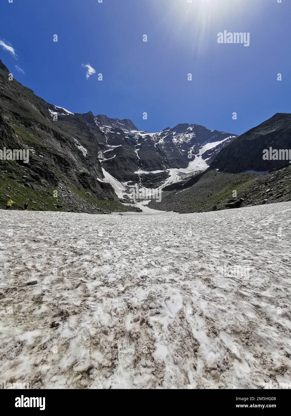 A vertical of the snow-covered mountain trail going through the Alpine ...