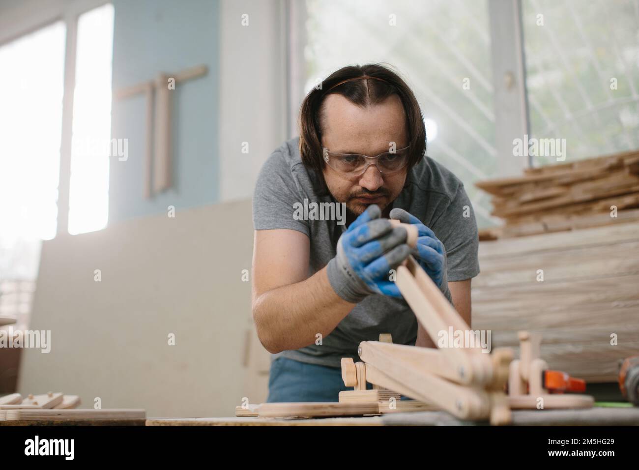 A carpenter makes wooden toys in a carpentry workshop. Making a bed ...