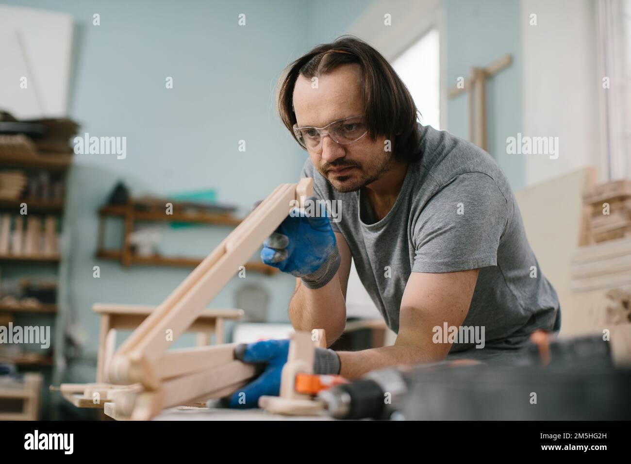 A carpenter makes wooden toys in a carpentry workshop. Making a bed ...