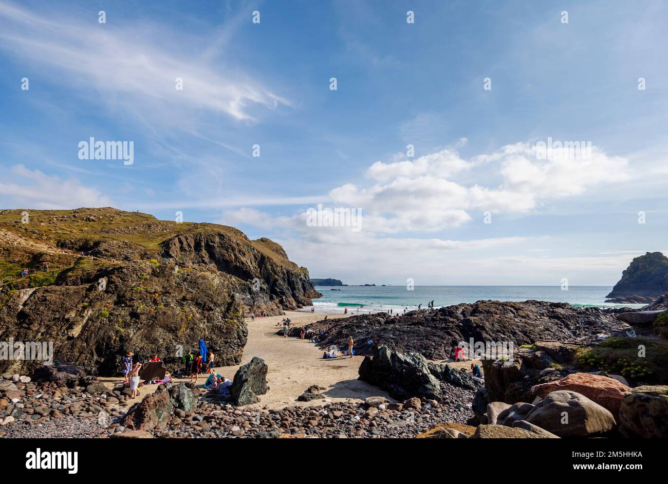 View of the sandy and rocky beach and cliffs in afternoon sun at ...