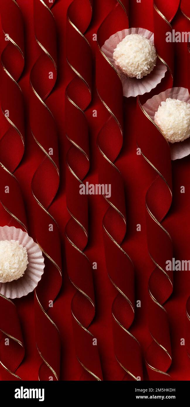 Coconut pralines on velvet red curvy laces, festive dessert background ...
