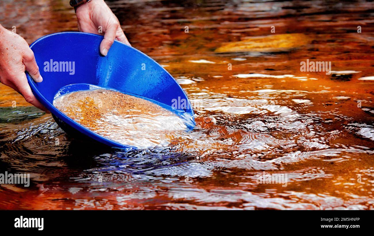 A man gold panning in a Scottish river Stock Photo - Alamy