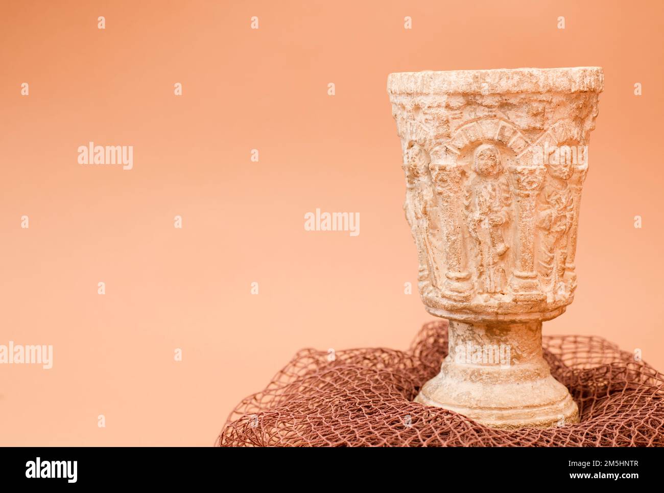 stone chalice with fishing net on a brown background Stock Photo - Alamy