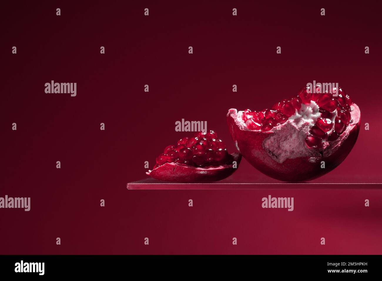 Red pomegranate fruit on magenta color background Stock Photo - Alamy