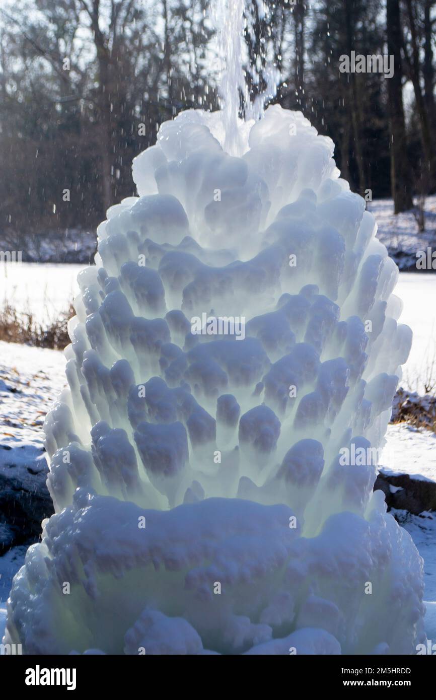 Iced fountain in the park on a winter sunny day. Fountain with frozen ...