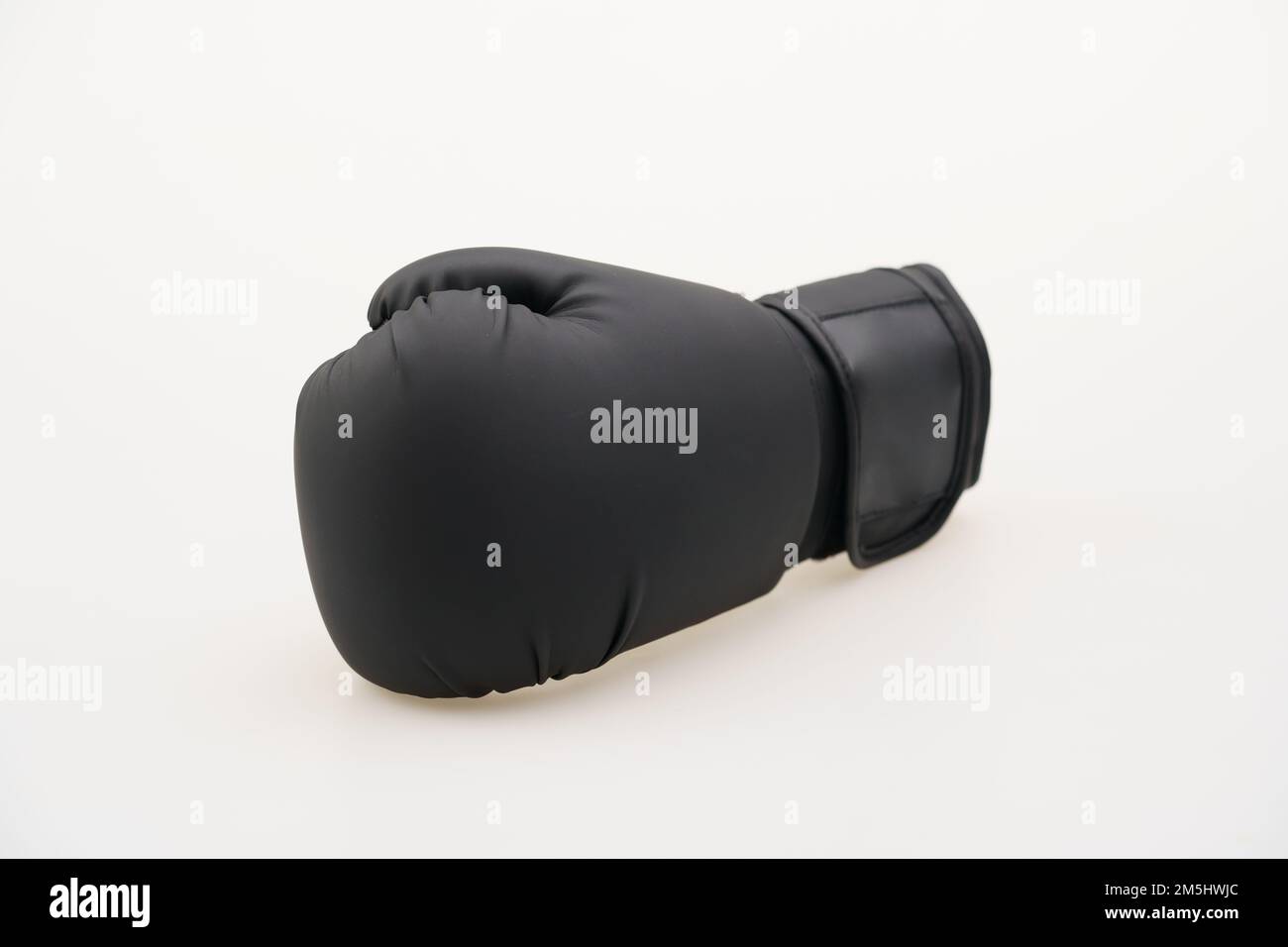 A single black boxing glove isolated on a white background Stock Photo ...