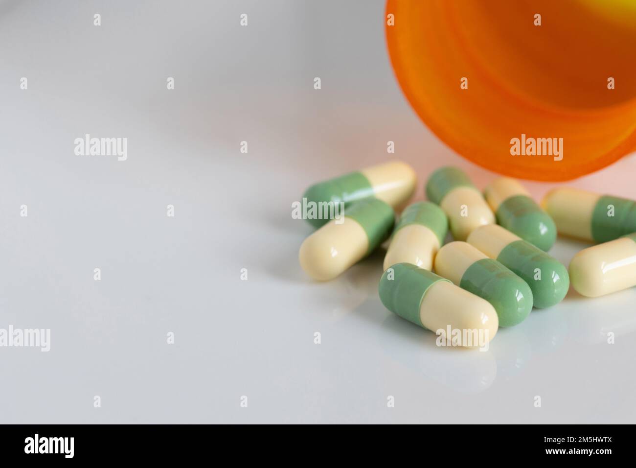 green and yellow capsule pills with a spilt prescription medication ...