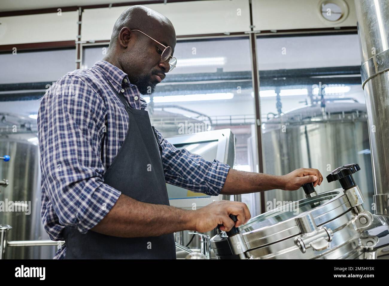 African American engineer concentrating on his work, he controlling ...