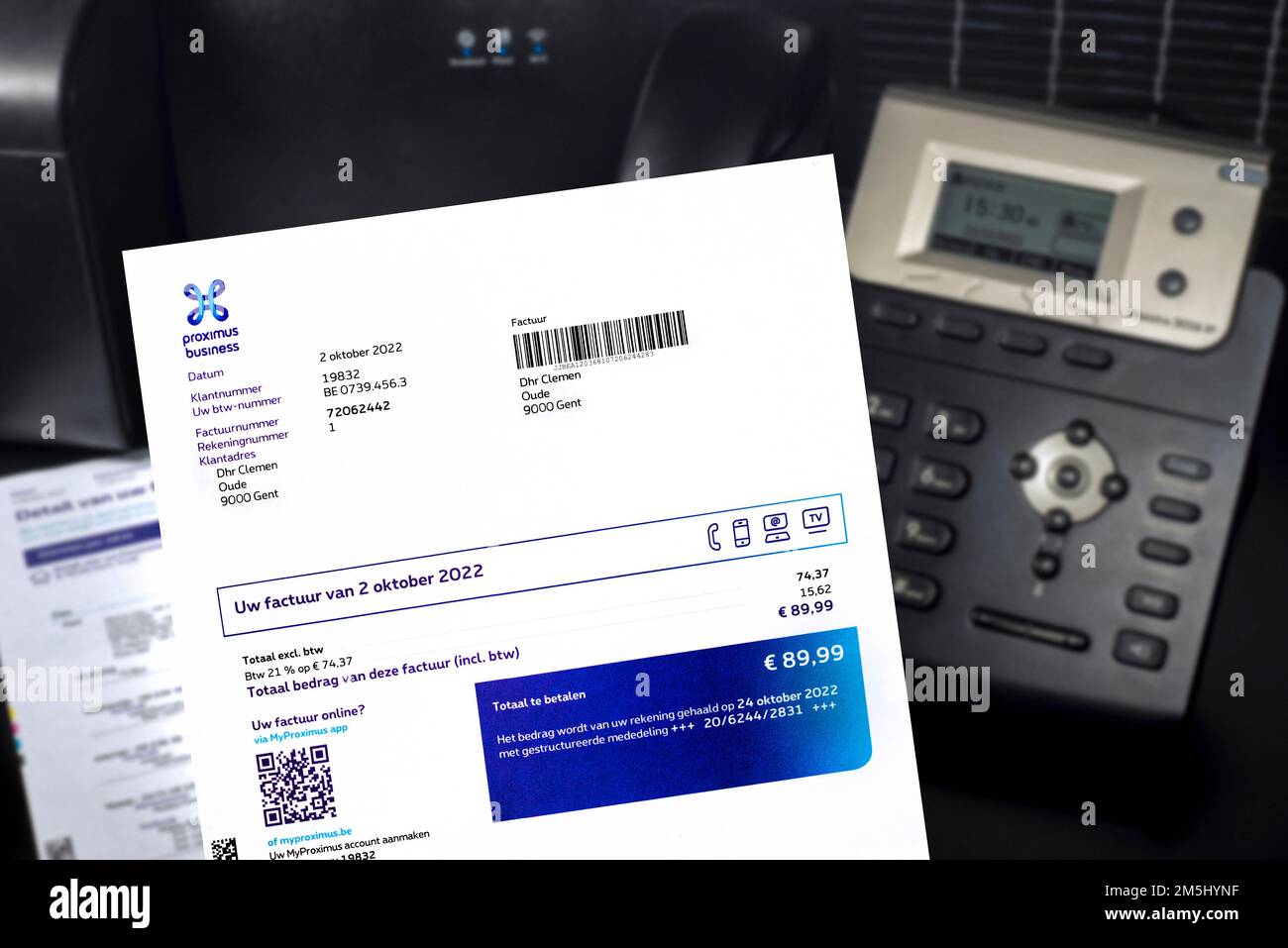 Invoice in front of black IP desktop telephone and internet modem from ...