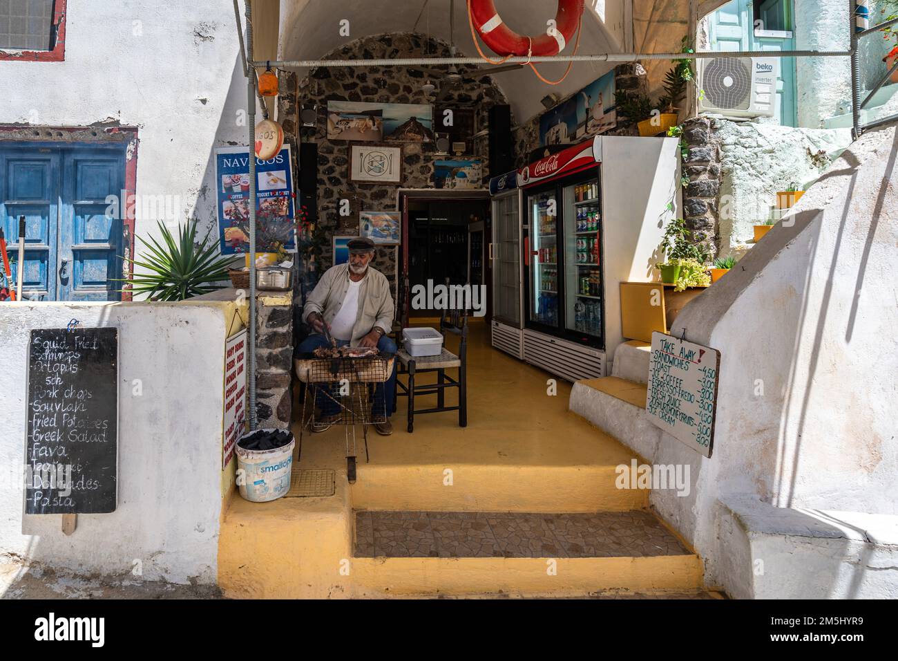 A horizontal view of a typical bar in Fira town, Santorini with an old ...