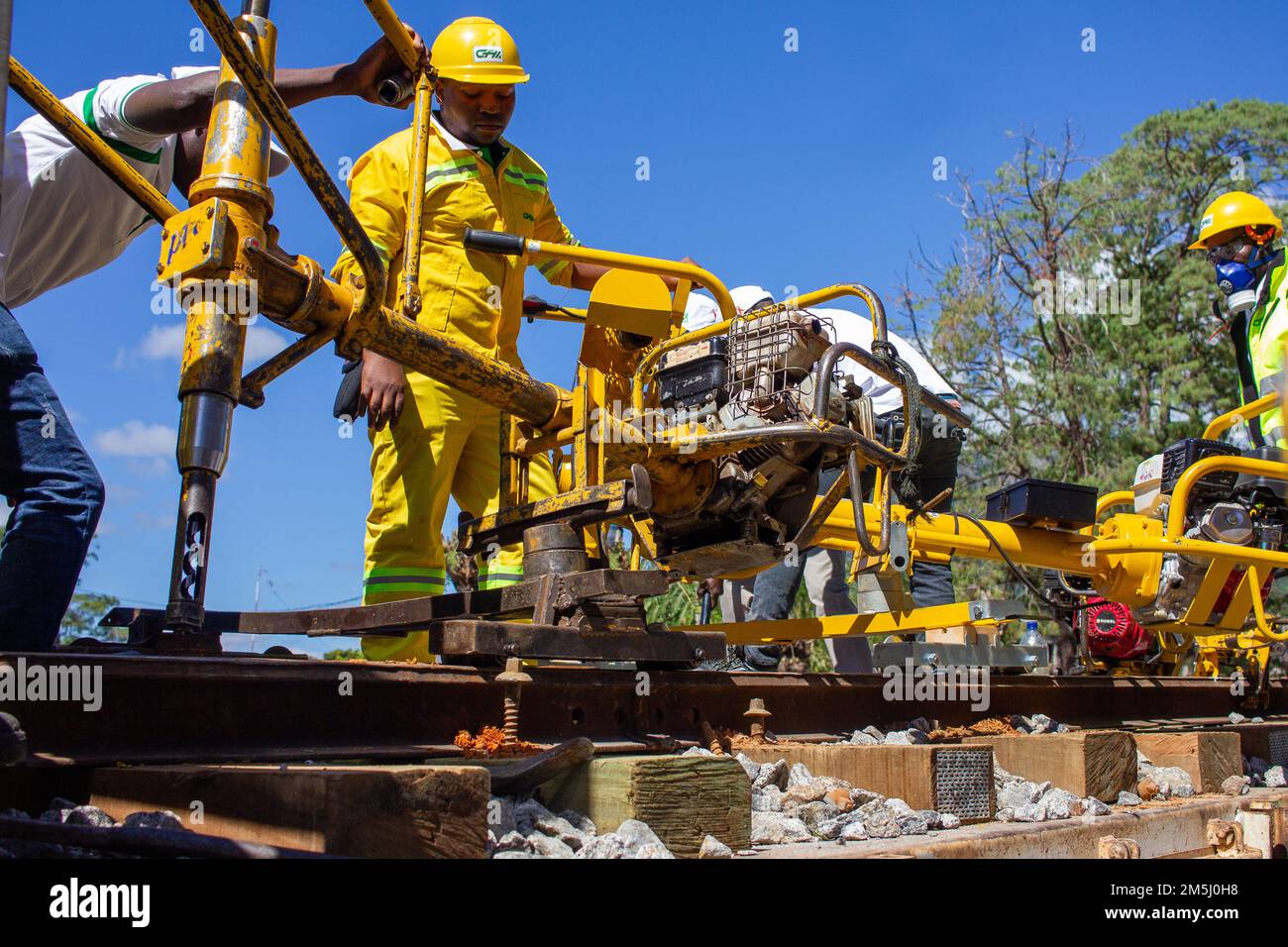 Workers Using a Mechanical Power Wrench to Bolt a Railway Track ...