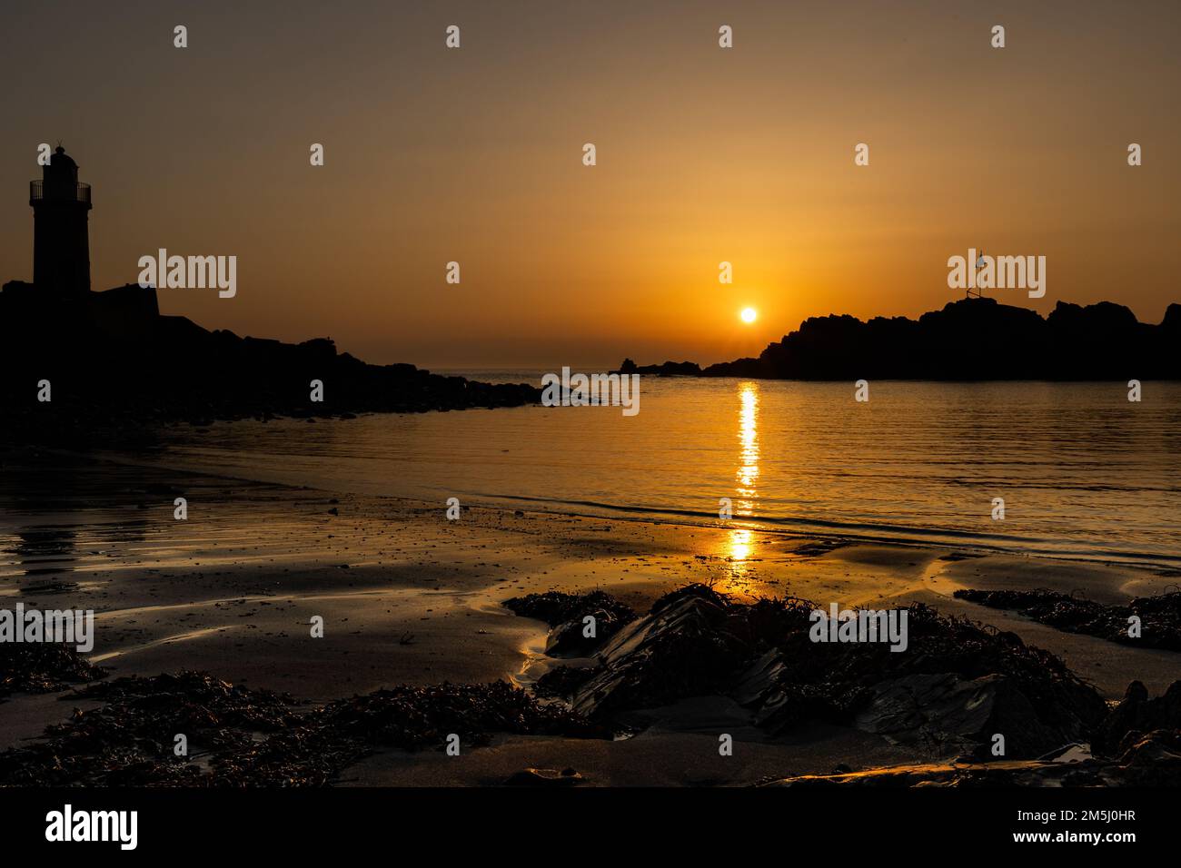 A silhouette of a lighthouse near the ocean at sunset Stock Photo - Alamy