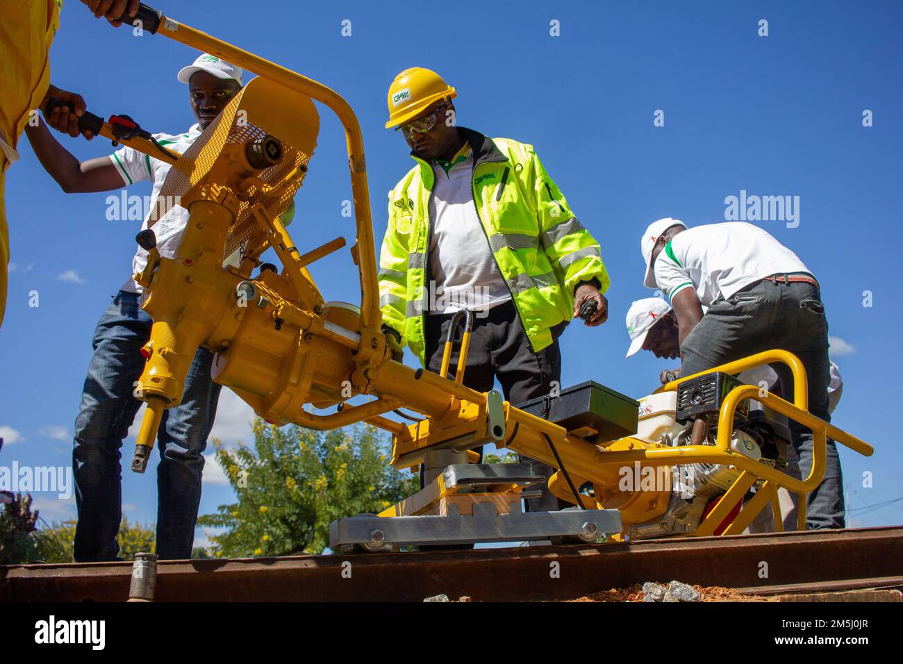 Workers Using a Mechanical Power Wrench to Bolt a Railway Track ...