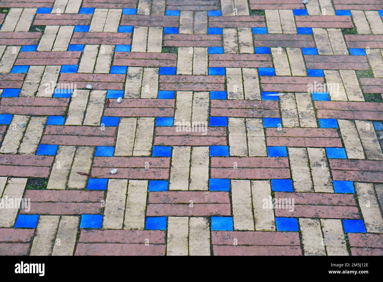 A closeup shot of colorful paving stones in the form of mosaic, dirty ...