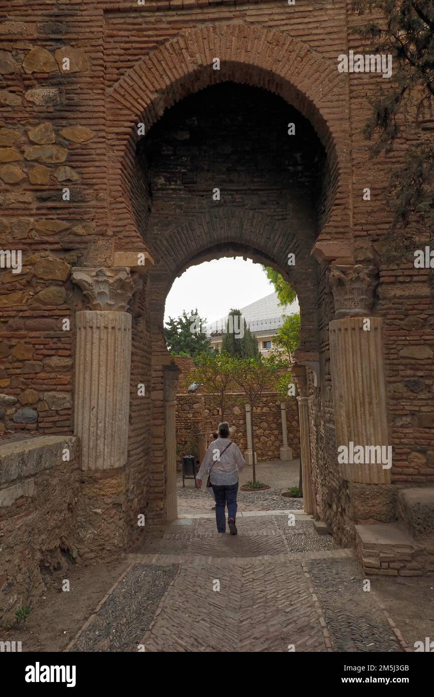 woman walks through the arch of the Columns where repurposed Roman ...