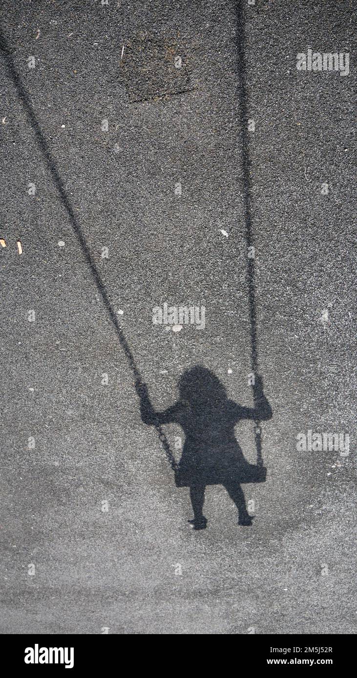 Kids on swings shadow Stock Photo - Alamy