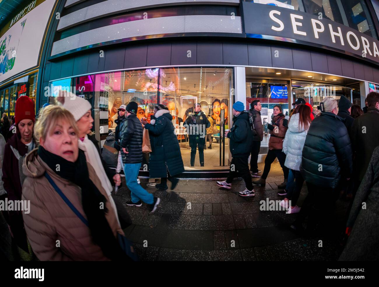 NYPD officer inside a Sephora store watches visitors descend on Times ...