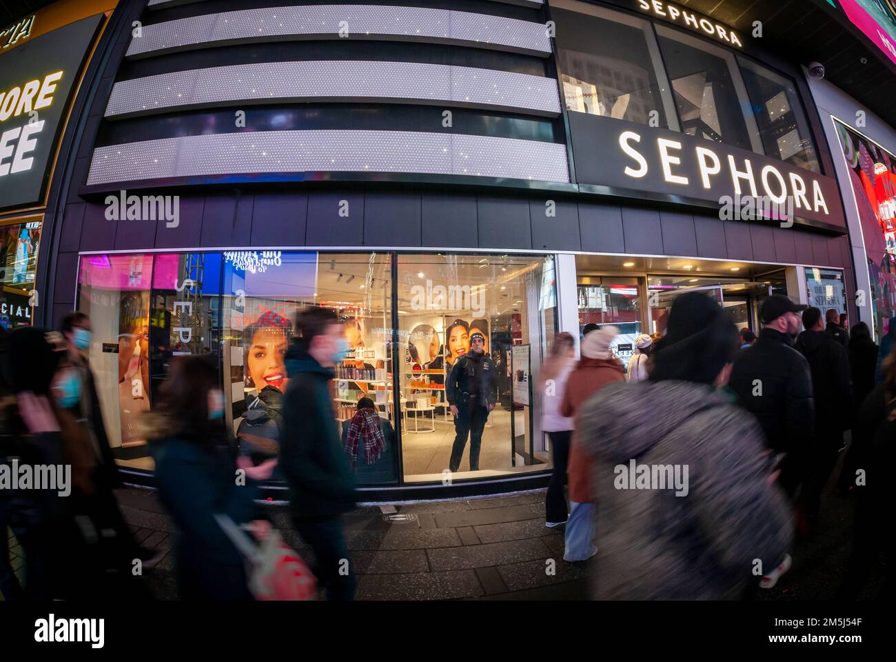 NYPD officer inside a Sephora store watches visitors descend on Times ...