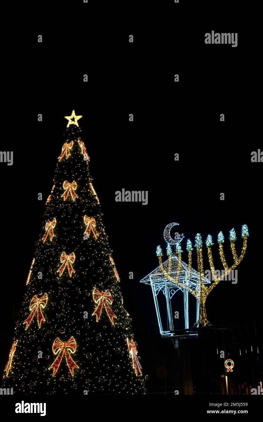 A decorated Christmas tree with illuminated Hanukkah menorah and the ...