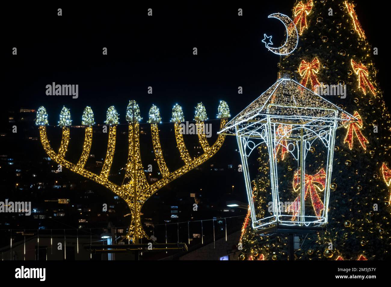 A decorated Christmas tree with illuminated Hanukkah menorah and the ...