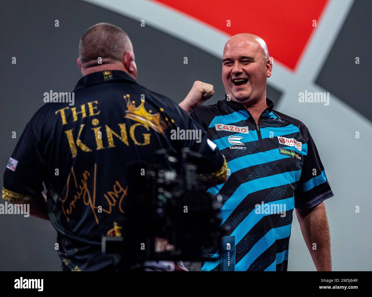 Rob Cross (right) celebrates winning his match against Mervyn King ...