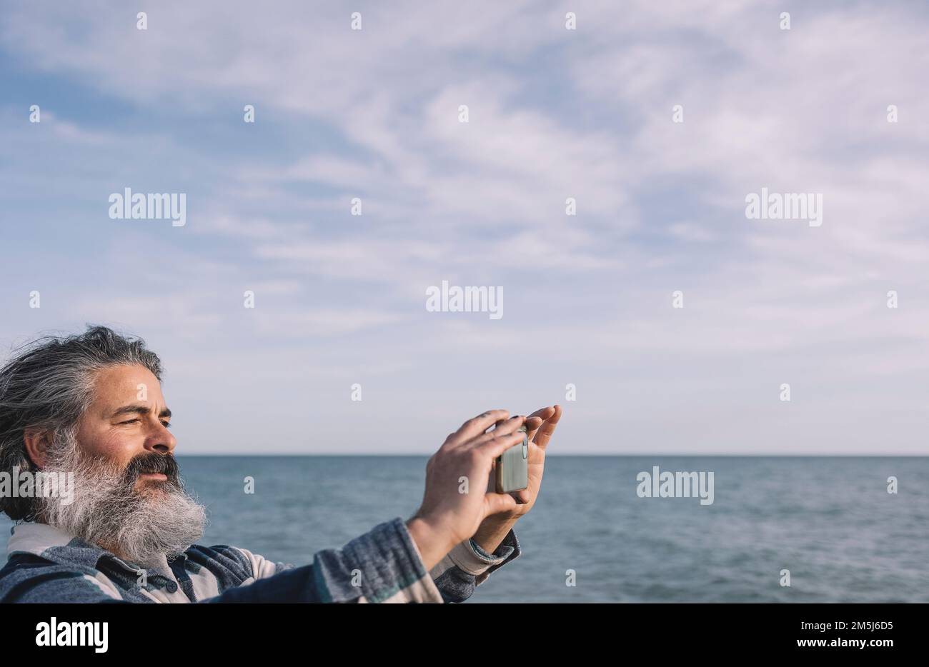 Happy bearded man taking selfie or photo with smart phone standing on ...