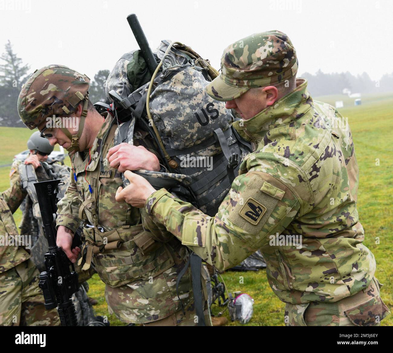 Oregon Army National Guard Soldiers assist each other with their ...