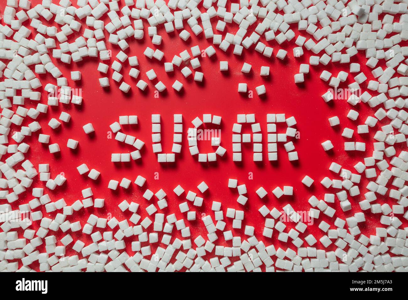 the word sugar is made up of sugar cubes on a red background. photo on ...