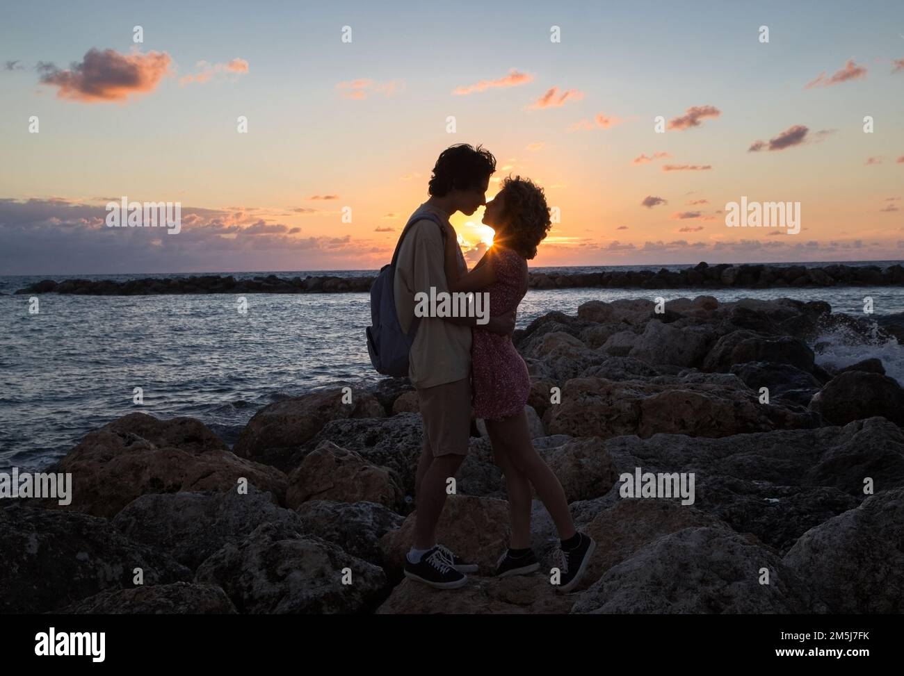 young adults in love, a teenager boy and girl hugging at sunset on the ...