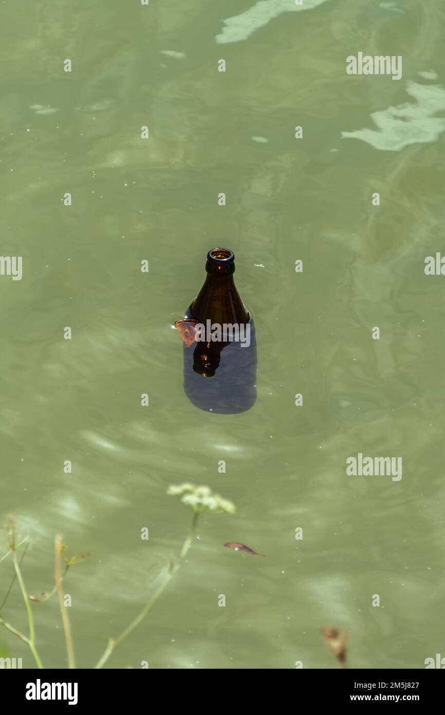 Floating Empty Beer Bottle In Green Water Stock Photo - Alamy