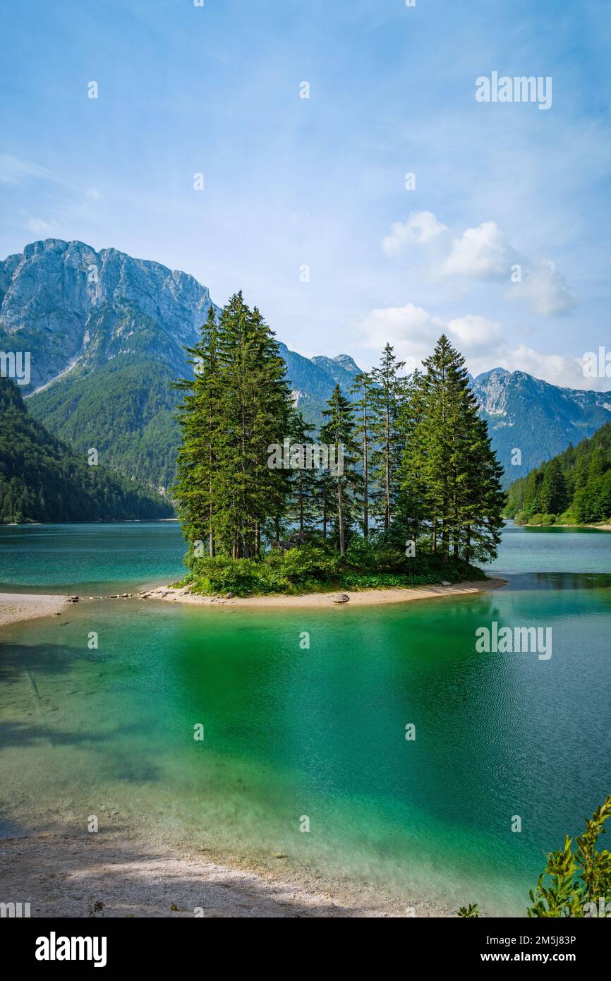 A breathtaking view of lush trees and emerald-green waters in Lago del ...