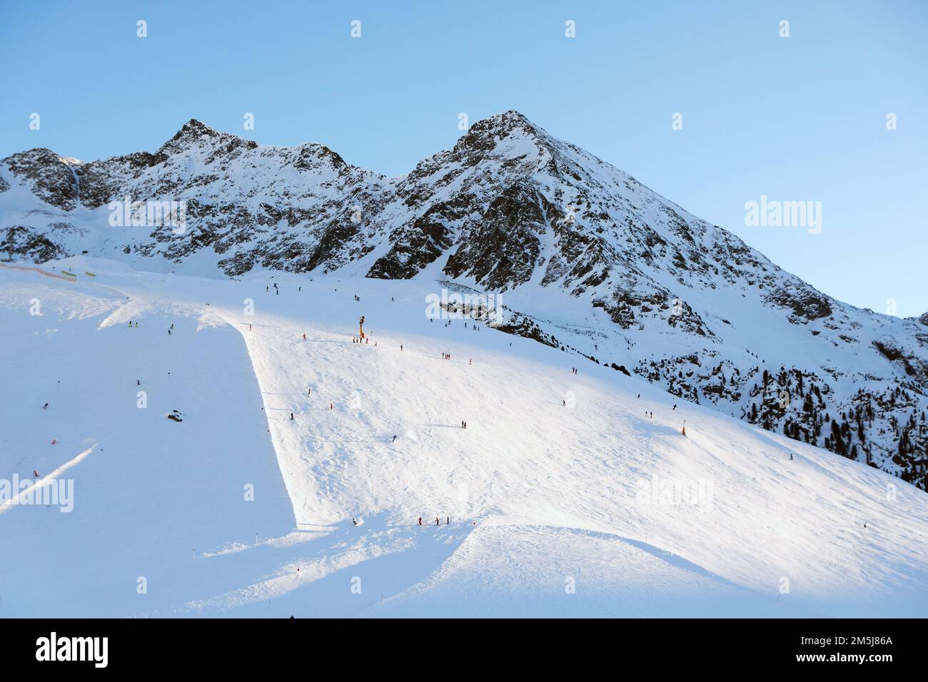 A beautiful view of a tall snowy mountain peak under a clear sky at the ...