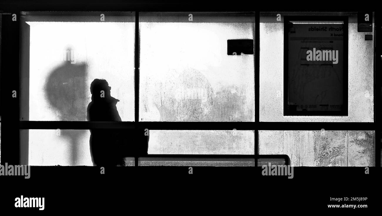 Lone housewife waiting for a bus on a wet midwinter day in North ...