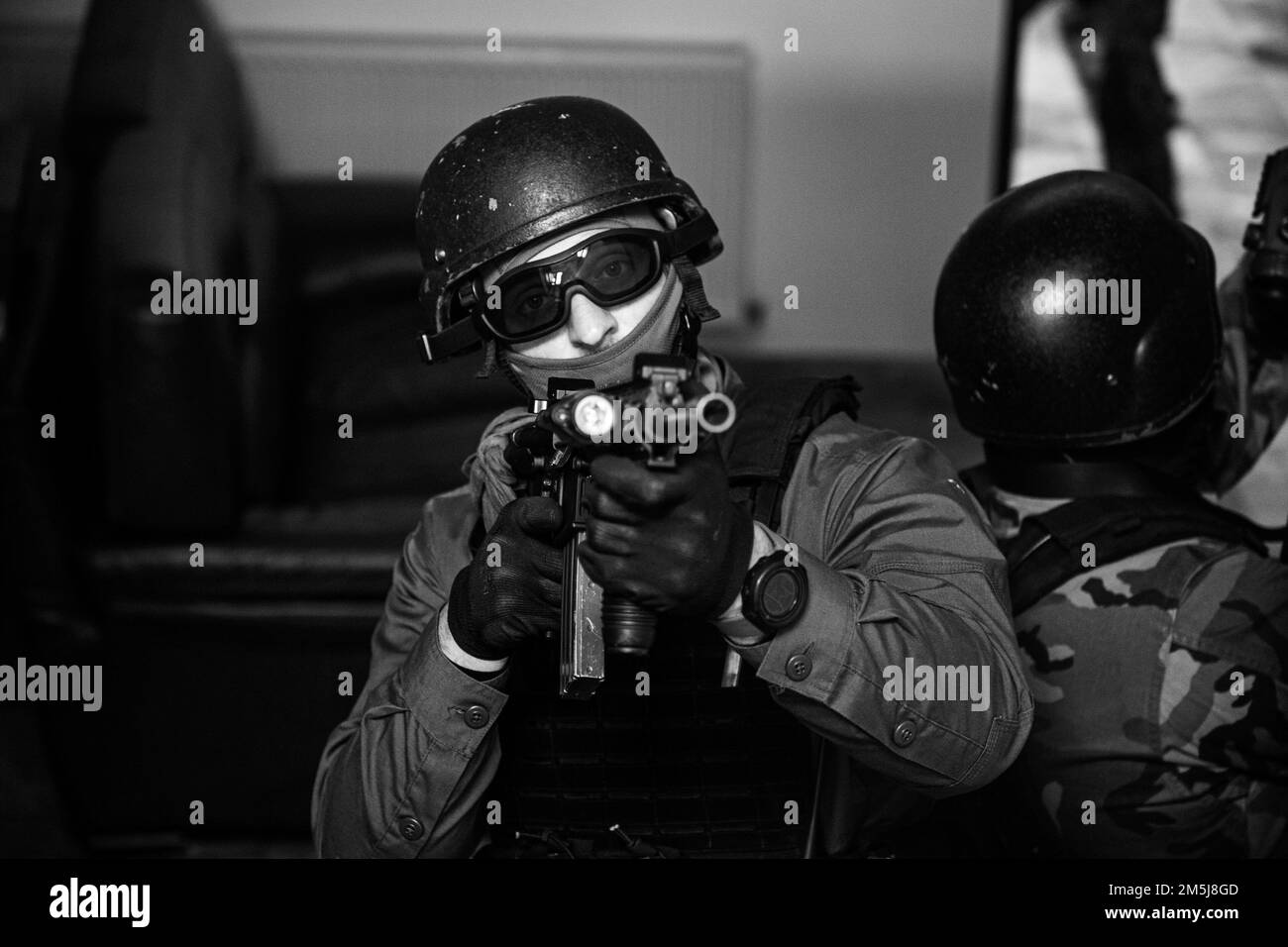 A member of Kosovo Special Intervention Unit aims his assault rifle at ...