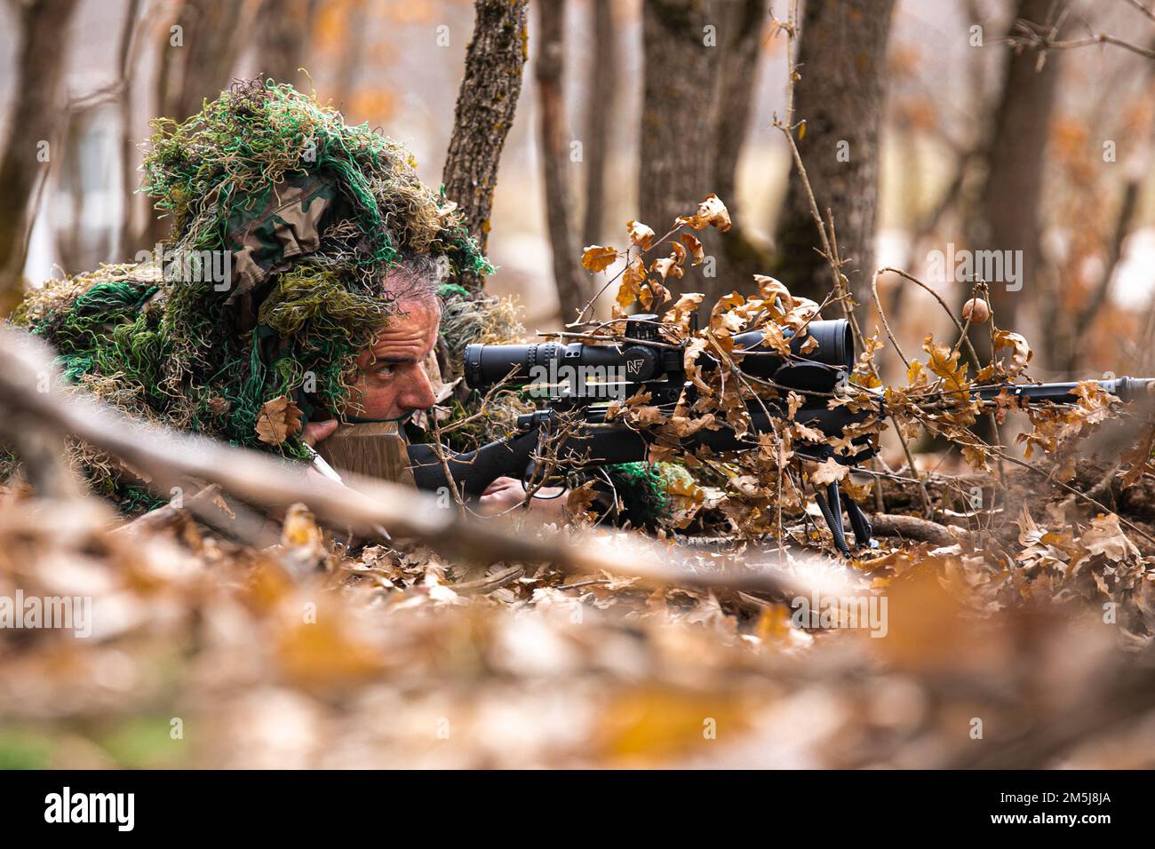 A member of Kosovo Special Intervention Unit shows terrain adaptation ...