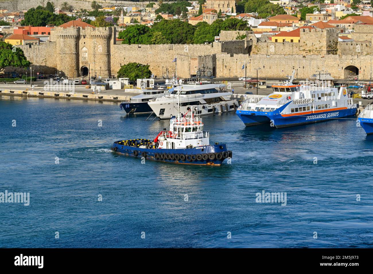 Rhodes, Greece - May 2022: Tug boat leaving the harbour of the town in ...
