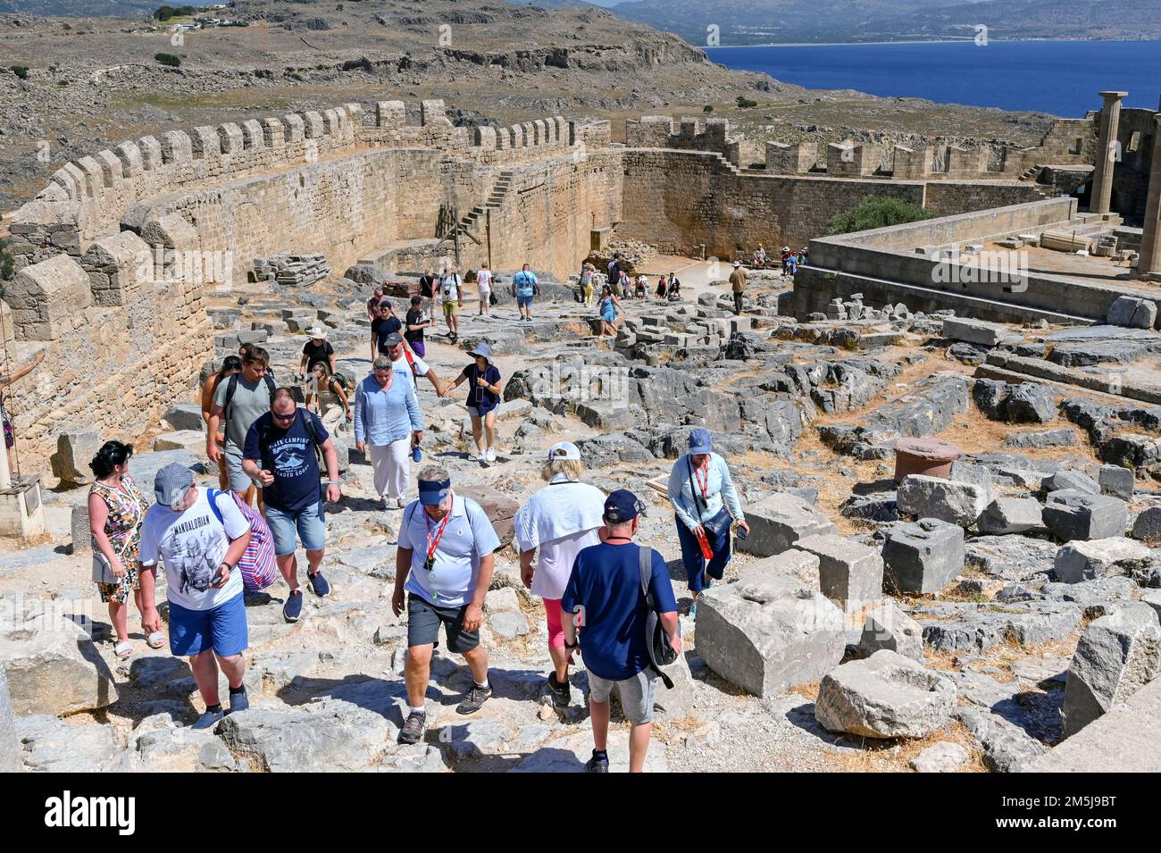 Lindos, Rhodes, Greece - May 2022: Tourists visiting the ancient ruins ...