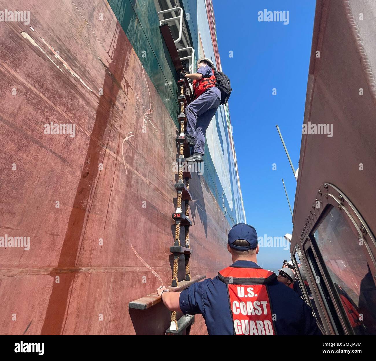 A Coast Guard investigative officer boards the grounded container ship ...