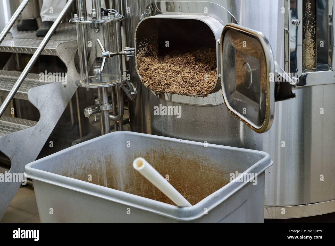 Close-up of pipe with waste inside of it falling down into the bin ...