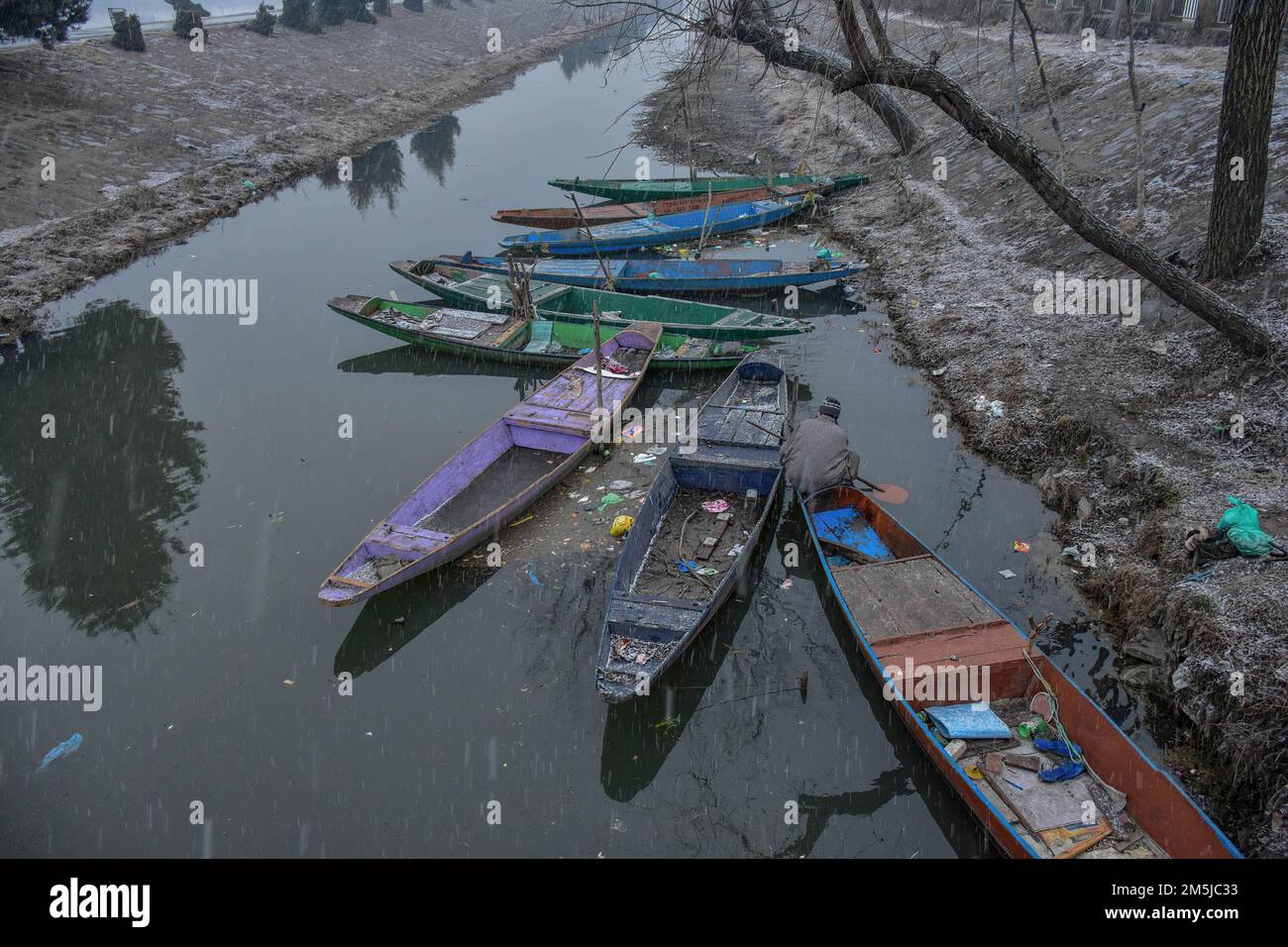 Srinagar, India. 29th Dec, 2022. A boatman rows his boat in the back ...