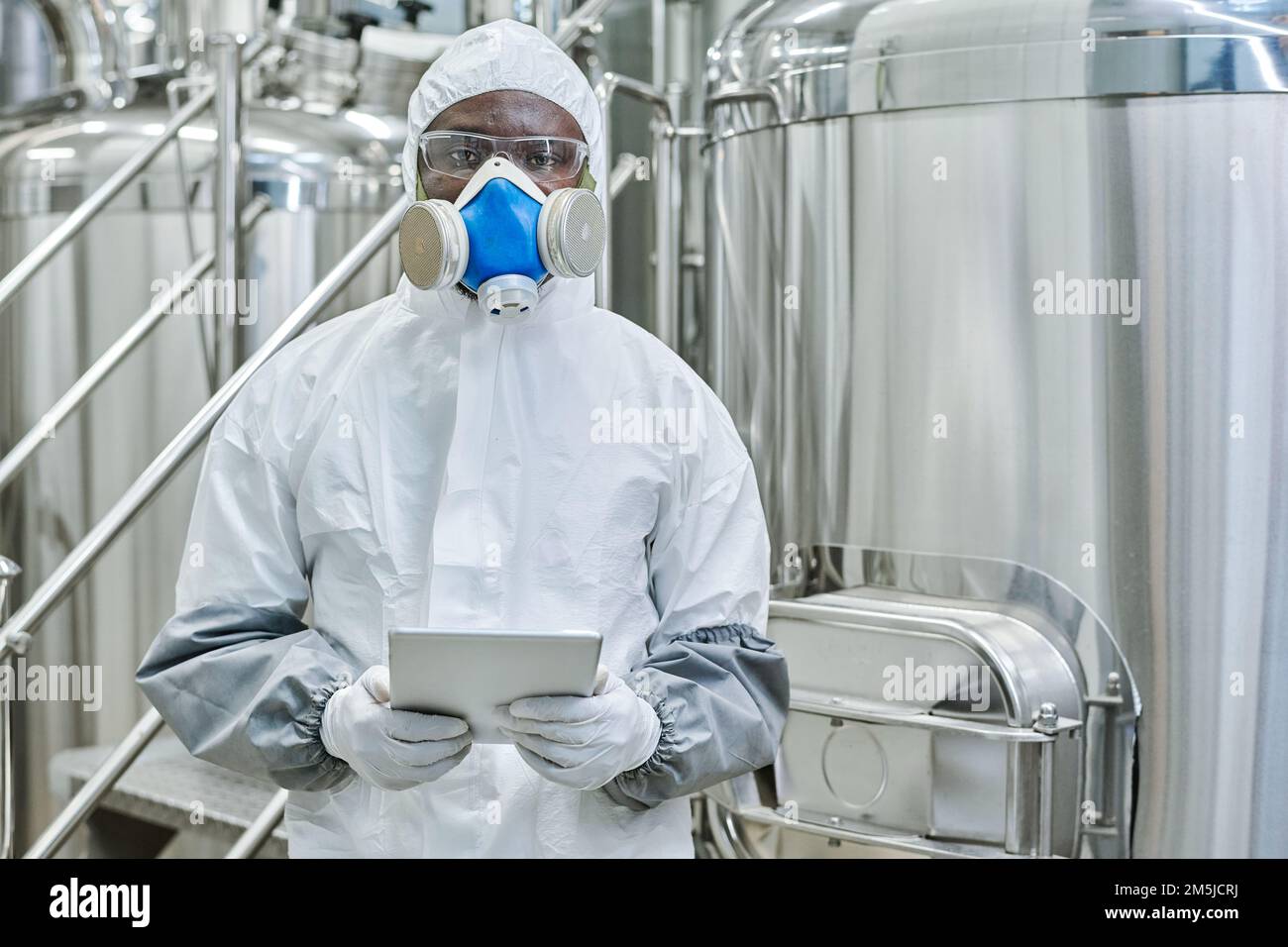 Portrait of African American engineer in respirator and protective ...