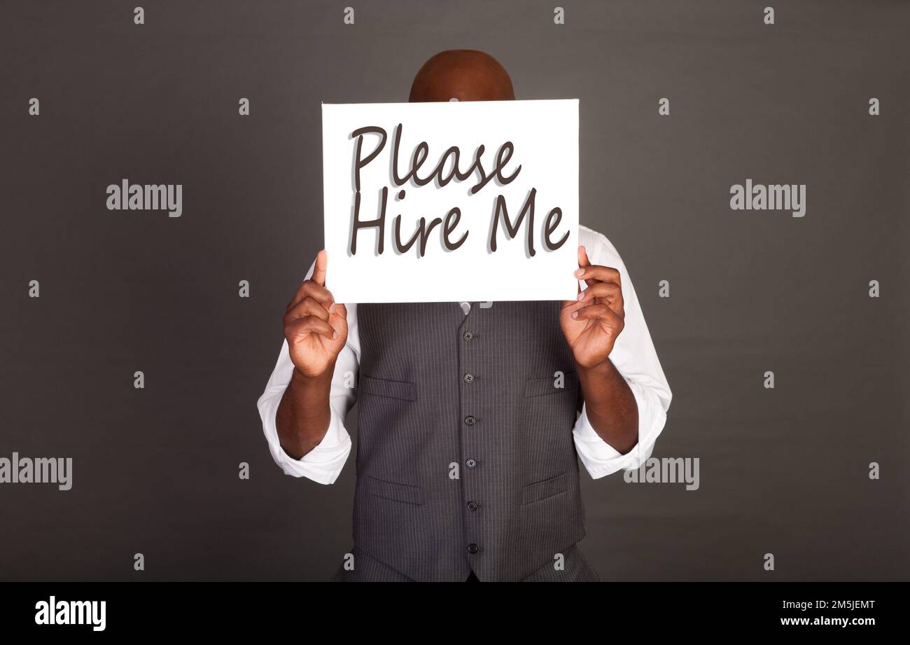 Young Black Business Man holding Please Hire Me Sign Stock Photo - Alamy