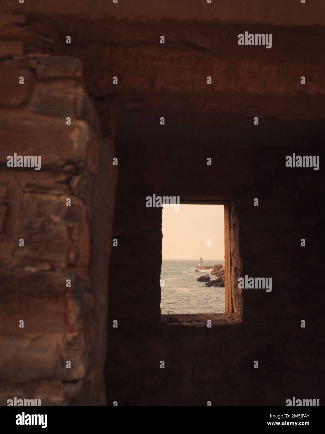 The lighthouse from the window of an old fortress, vertical Stock Photo ...