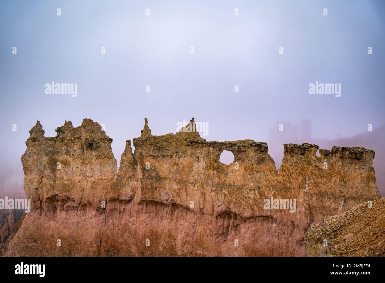 sandstone wall and hoodoos of bryce canyon covered in fog Stock Photo ...