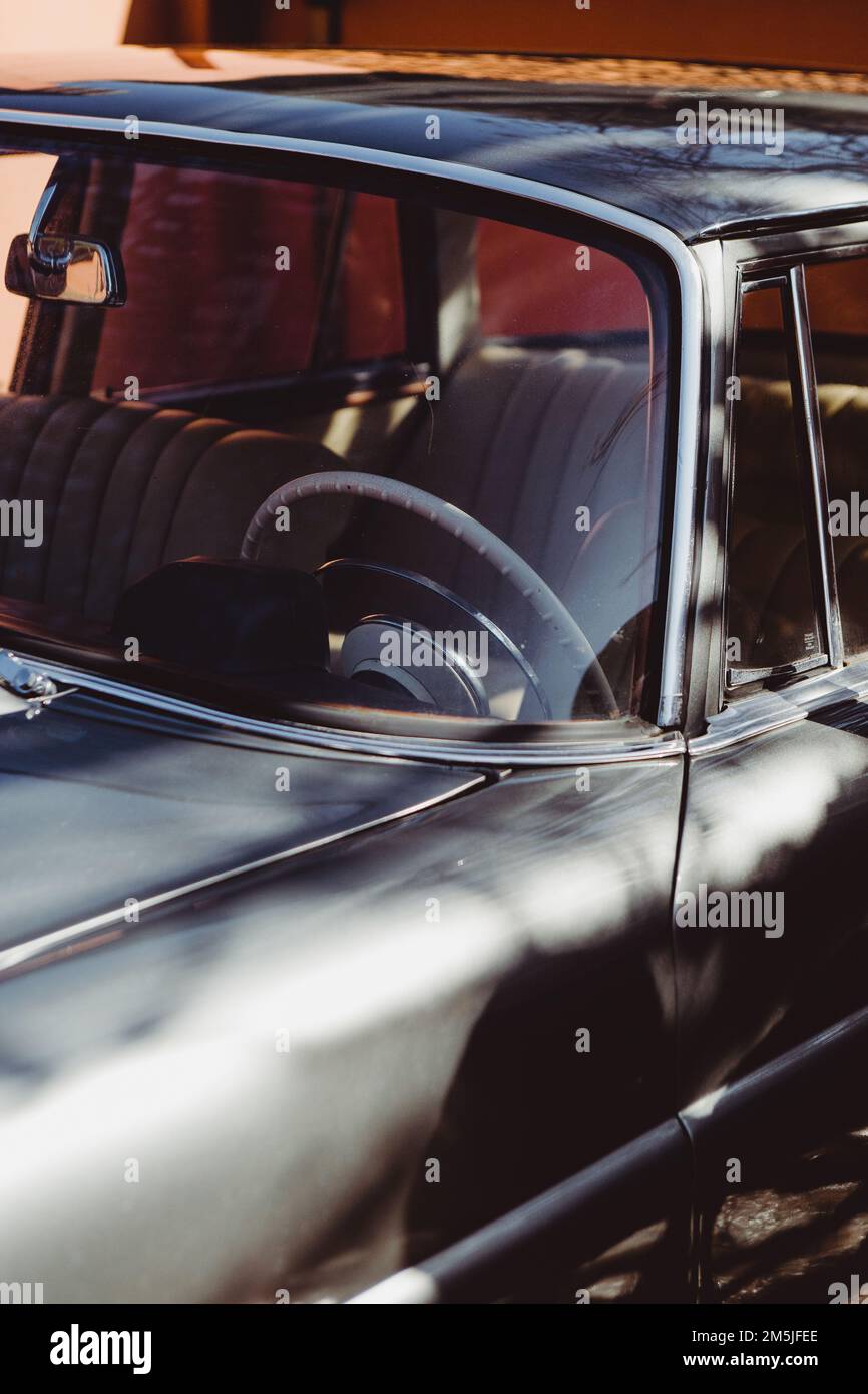 A vertical shot of the front of a classic old Mercedes Benz car in gray ...
